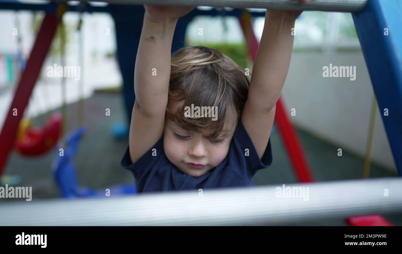 Child holding into monkey bar at playground kid falling down kid falls ...