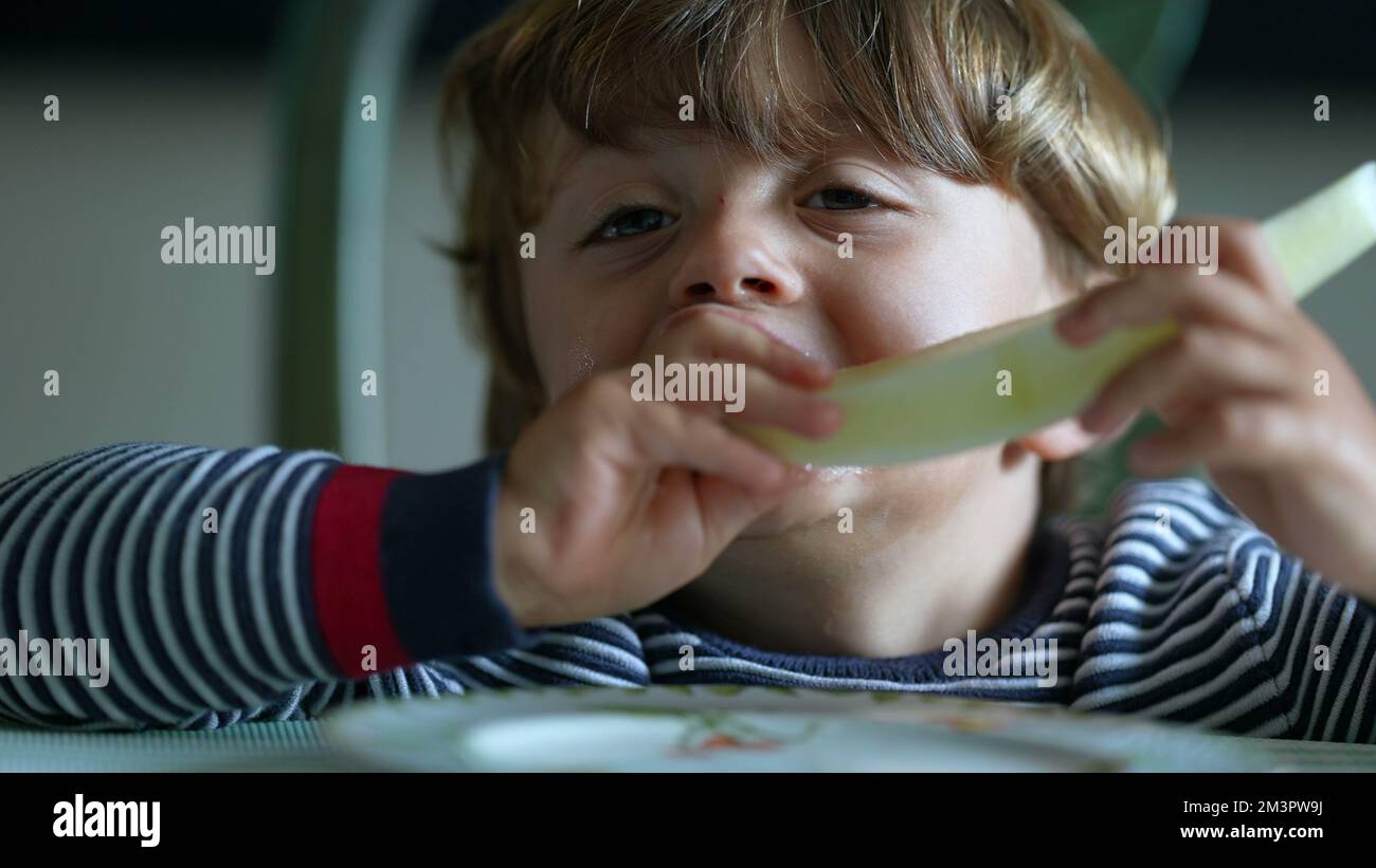 Child eating green melon fruit little boy eats healthy snack dessert ...