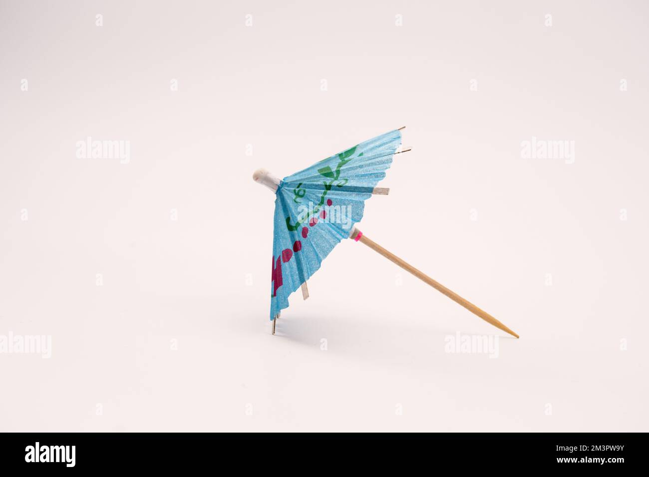 Single blue cocktail parasol umbrella isolated on a white background ...