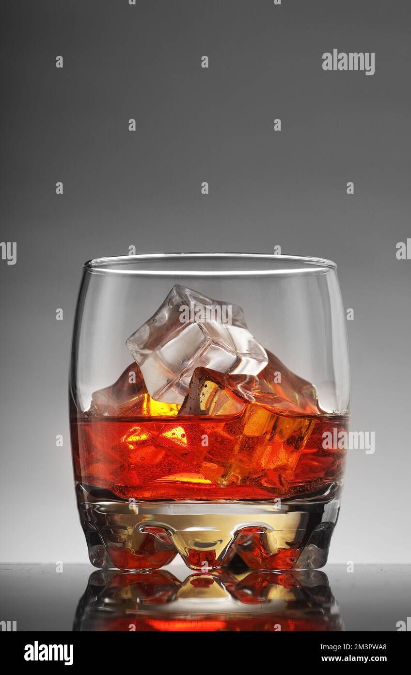 glass with alcohol and ice cubes on a white background Stock Photo - Alamy
