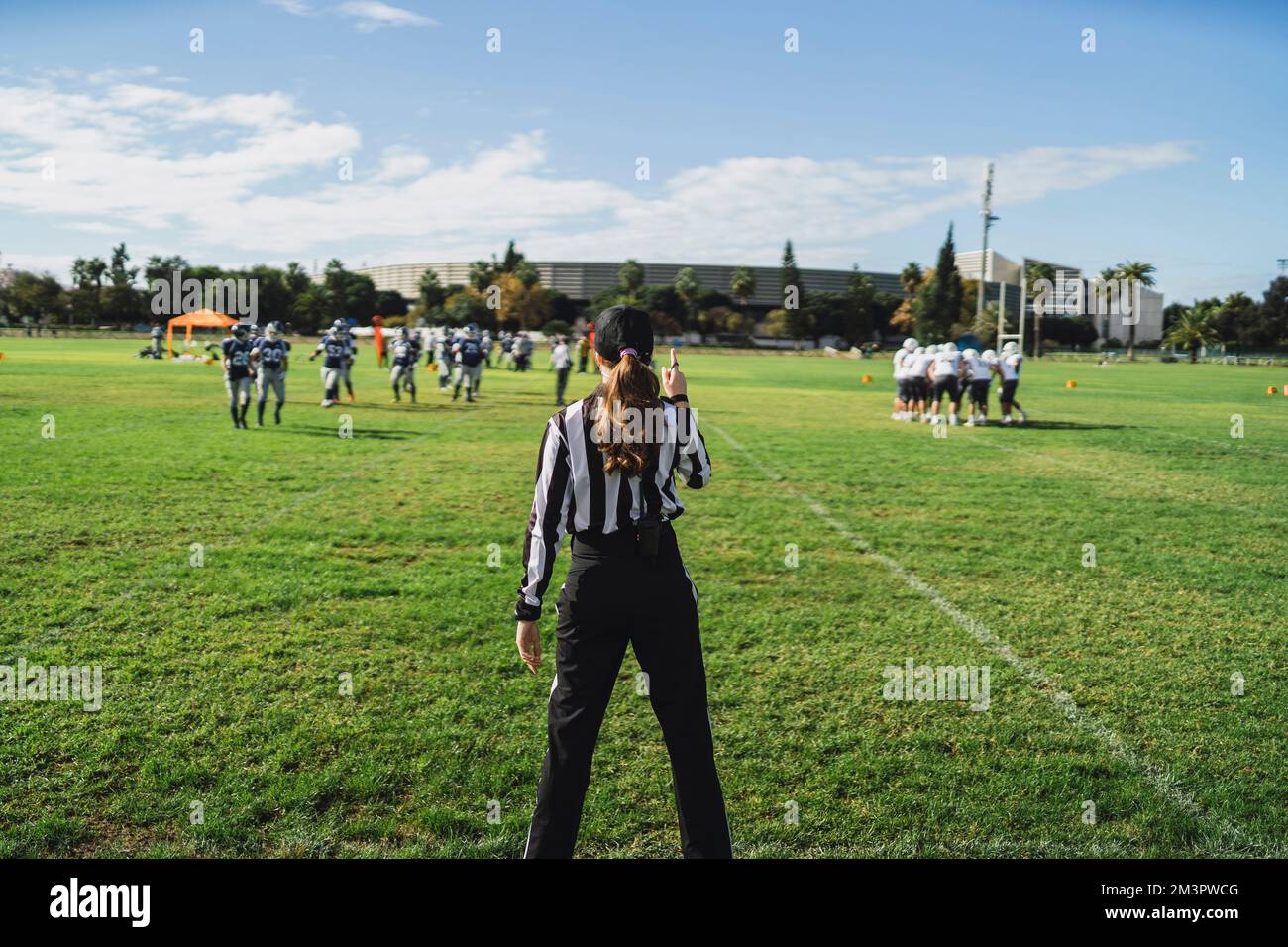 An American football referee standing on the field watching the game ...