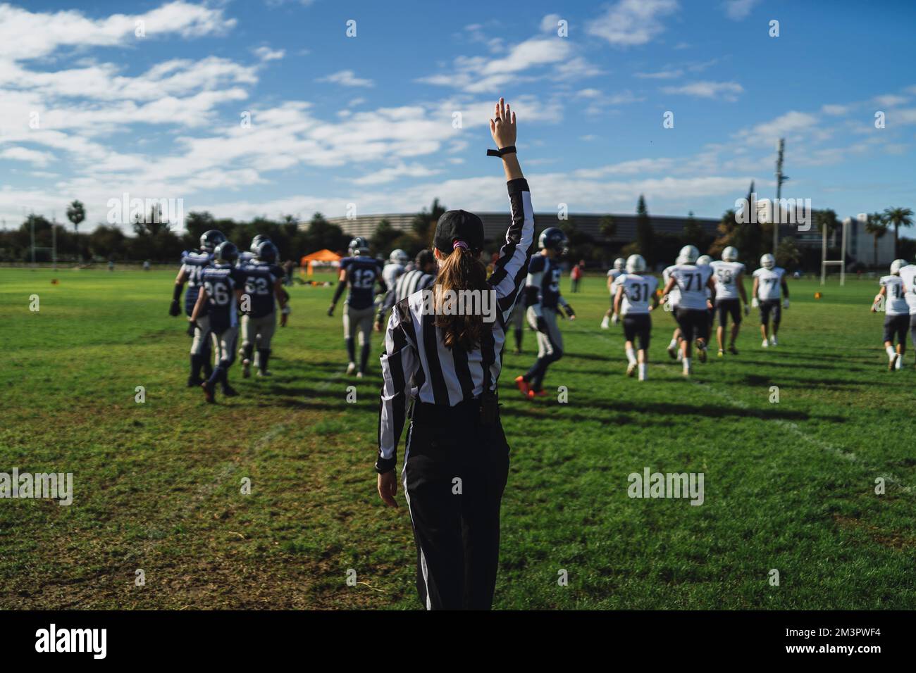 An American football referee standing on the field watching the game ...