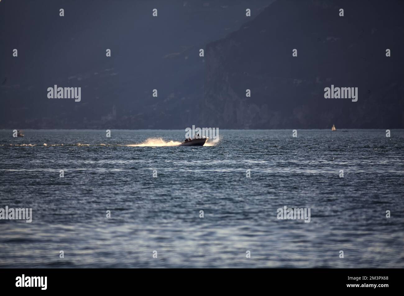 Motorboat on a lake seen from afar Stock Photo - Alamy