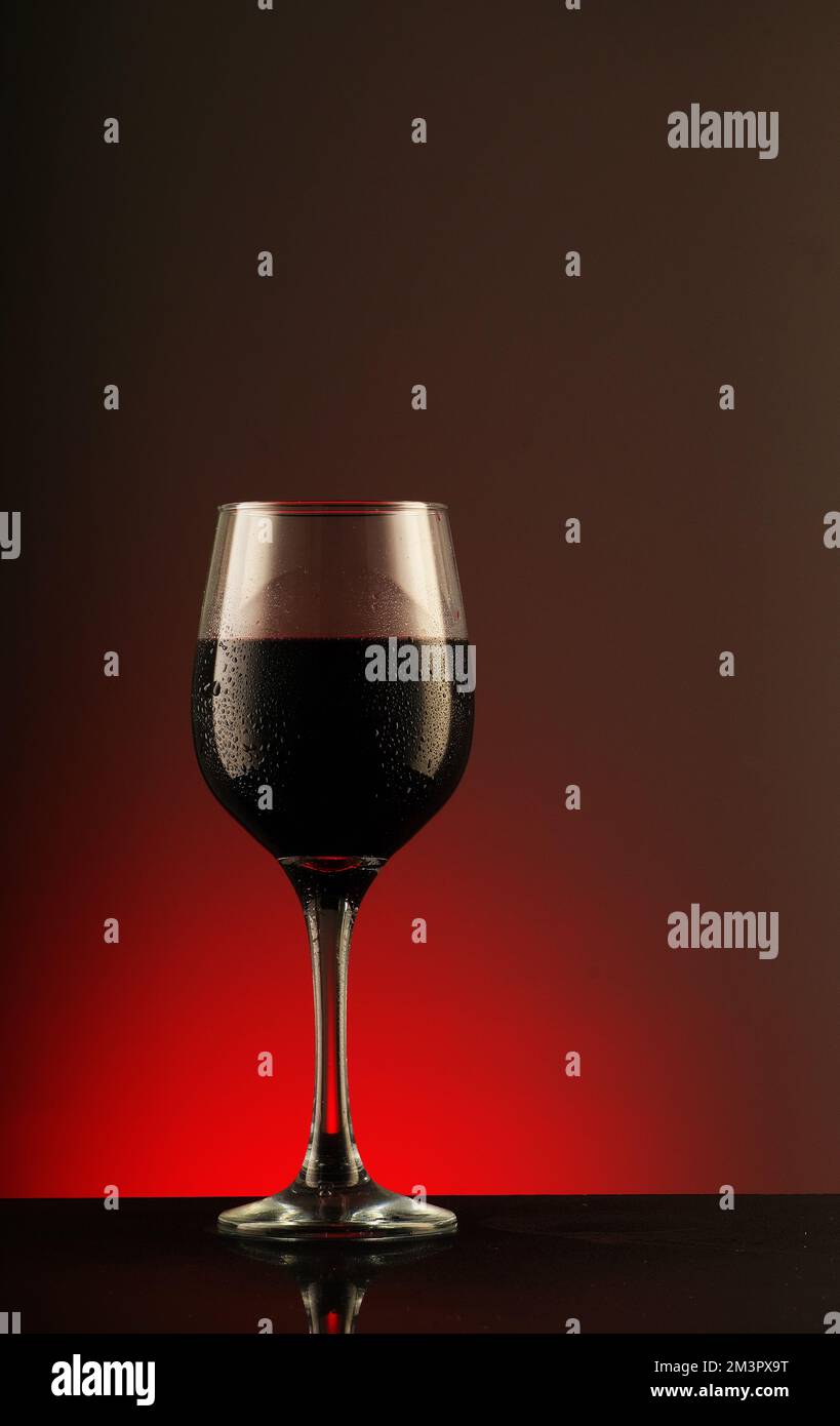 full goblet with wine over red background Stock Photo - Alamy