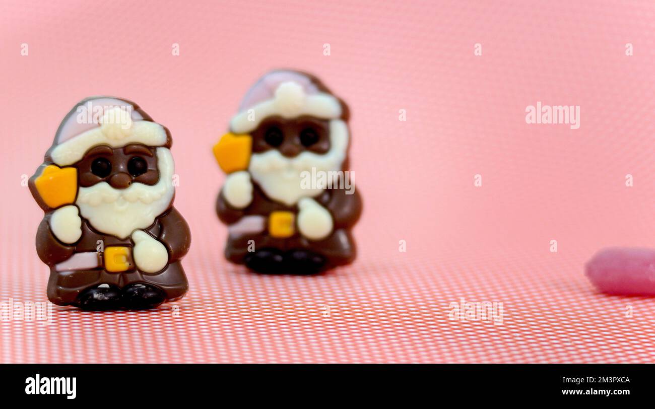 Tasty cute little chocolate Santa Claus candy on pink stripped ...