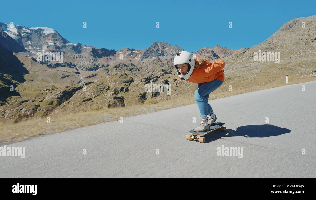 Cinematic downhill longboard session. Young woman skateboarding and ...