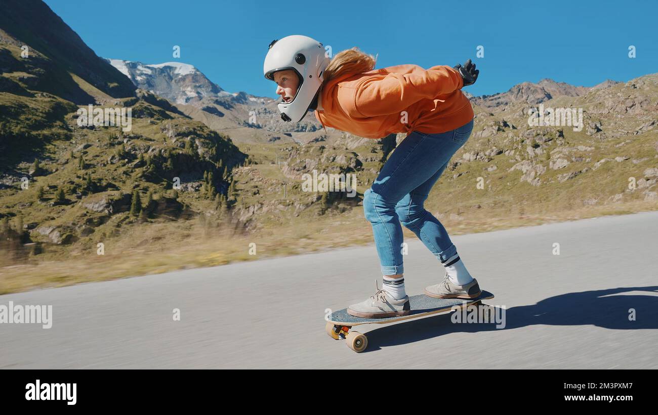 Cinematic downhill longboard session. Young woman skateboarding and ...