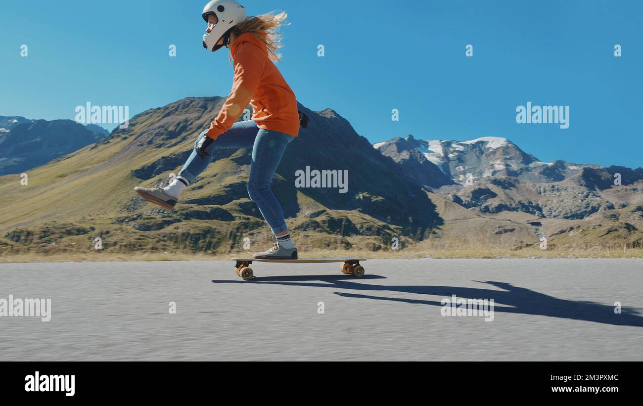 Cinematic downhill longboard session. Young woman skateboarding and ...
