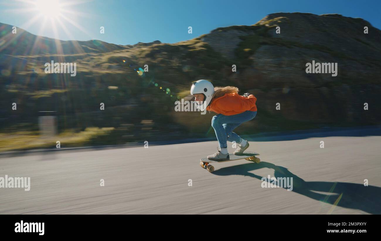 Cinematic downhill longboard session. Young woman skateboarding and ...