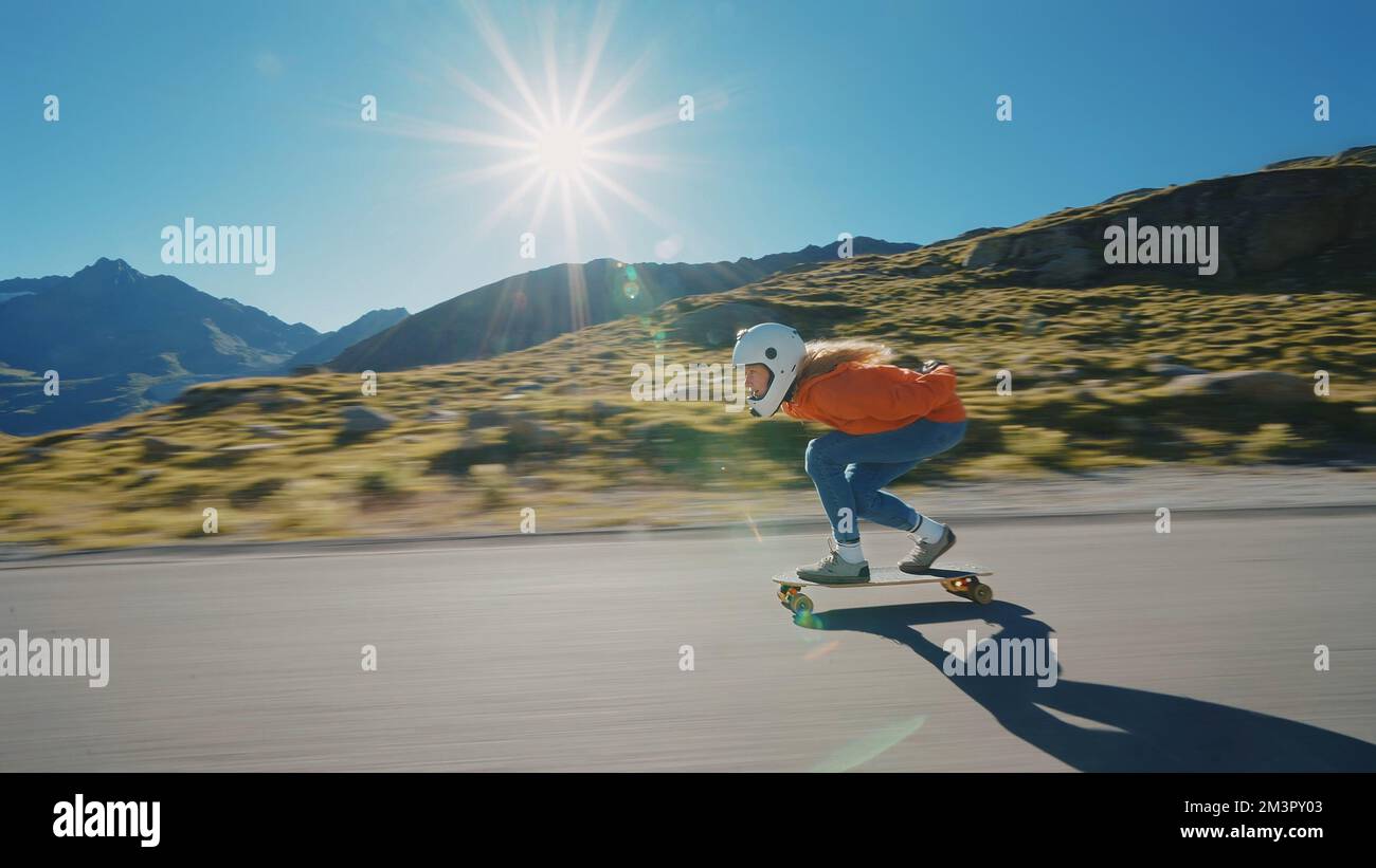 Cinematic downhill longboard session. Young woman skateboarding and ...