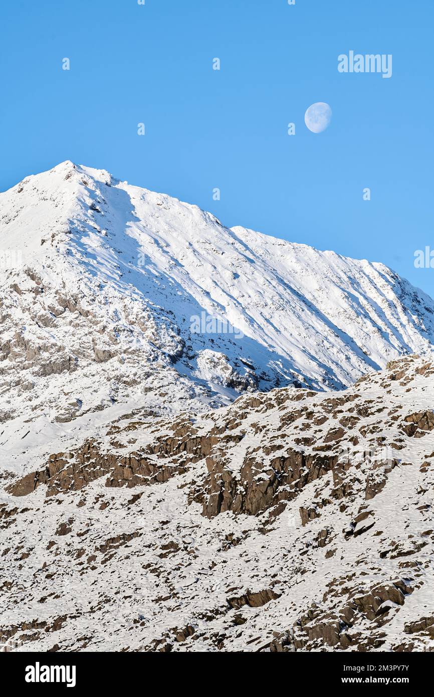 Moon above Snowdon mountain summit range on a day with a clear blue sky ...