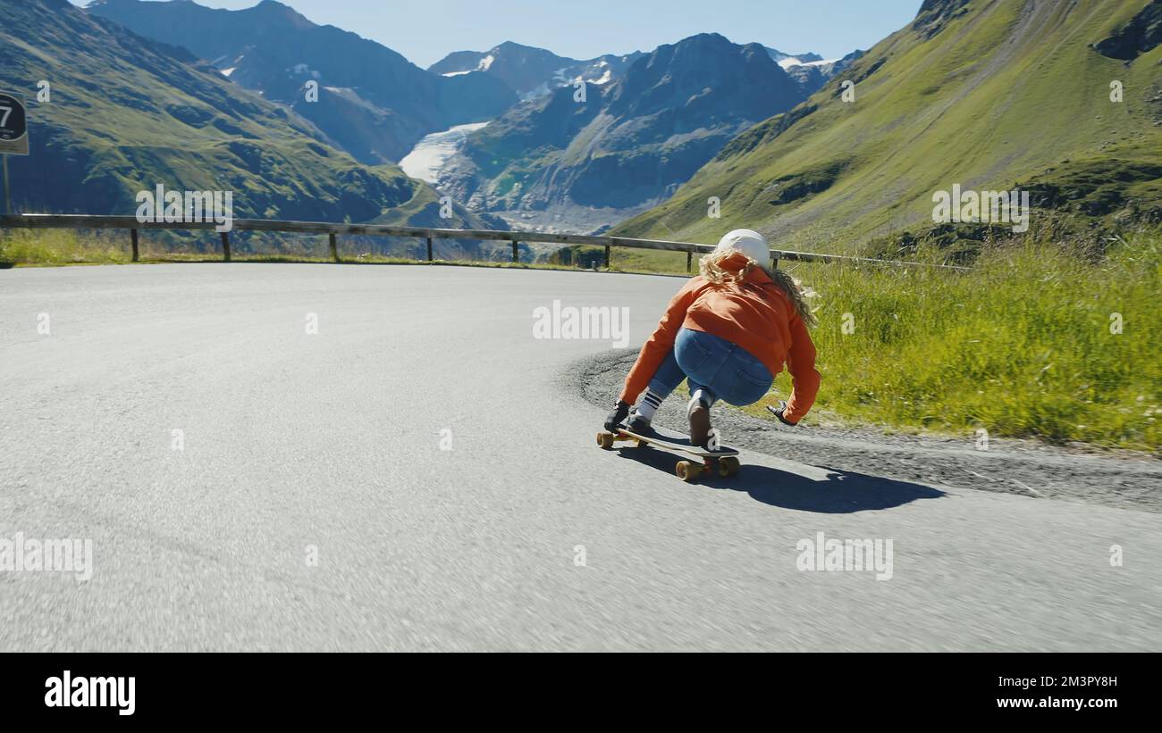 Cinematic downhill longboard session. Young woman skateboarding and ...
