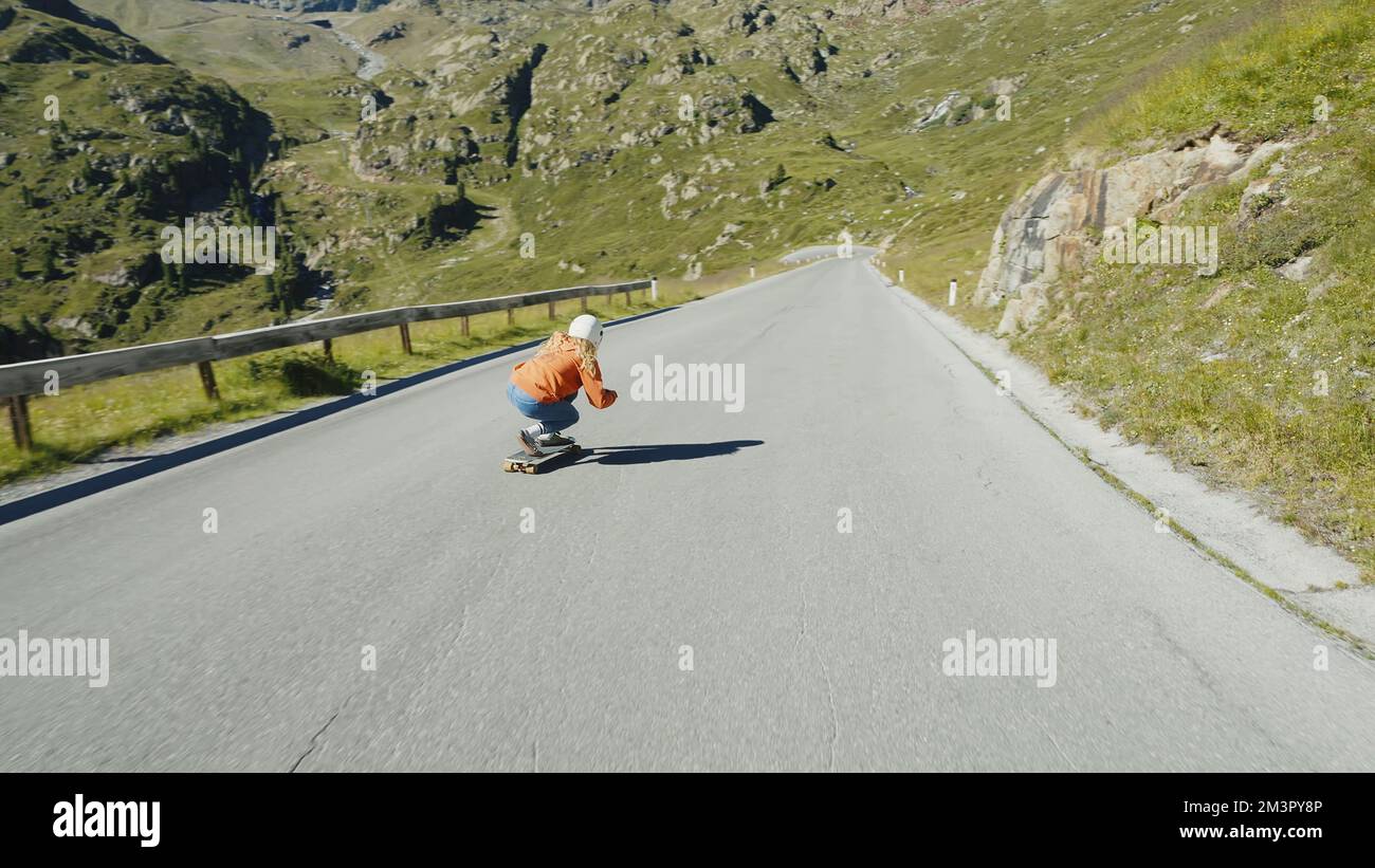 Cinematic downhill longboard session. Young woman skateboarding and ...
