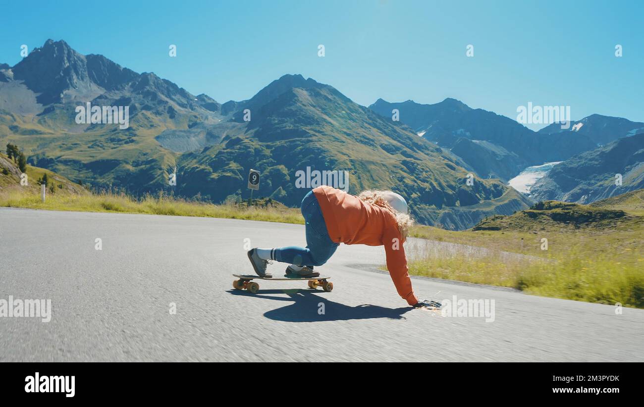 Cinematic downhill longboard session. Young woman skateboarding and ...