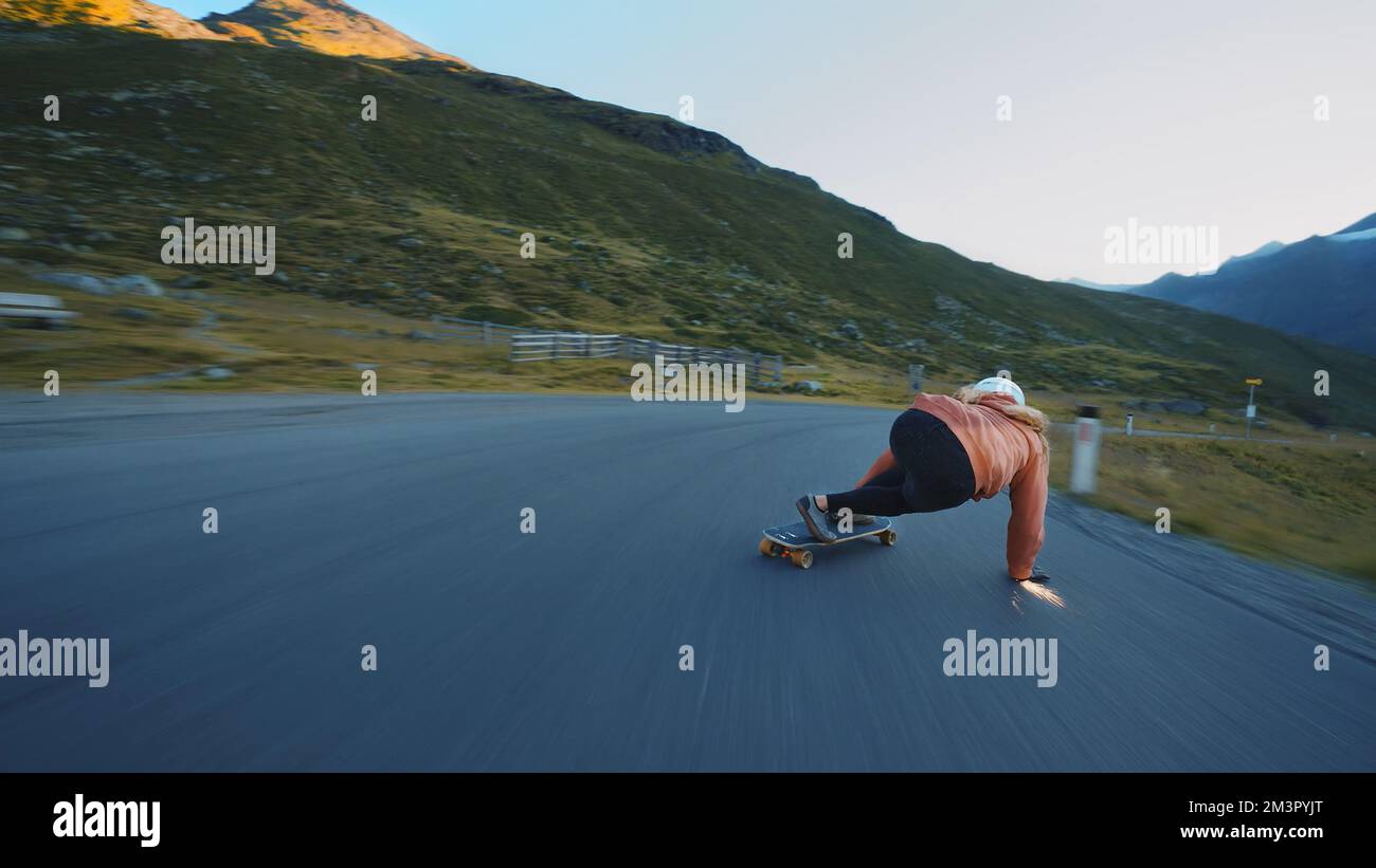 Cinematic downhill longboard session. Young woman skateboarding and ...