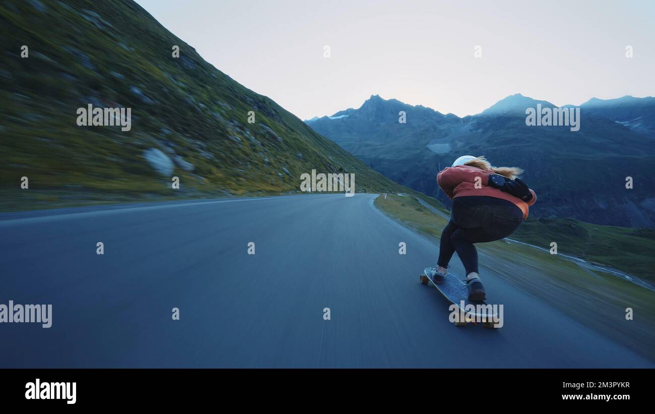 Cinematic downhill longboard session. Young woman skateboarding and ...