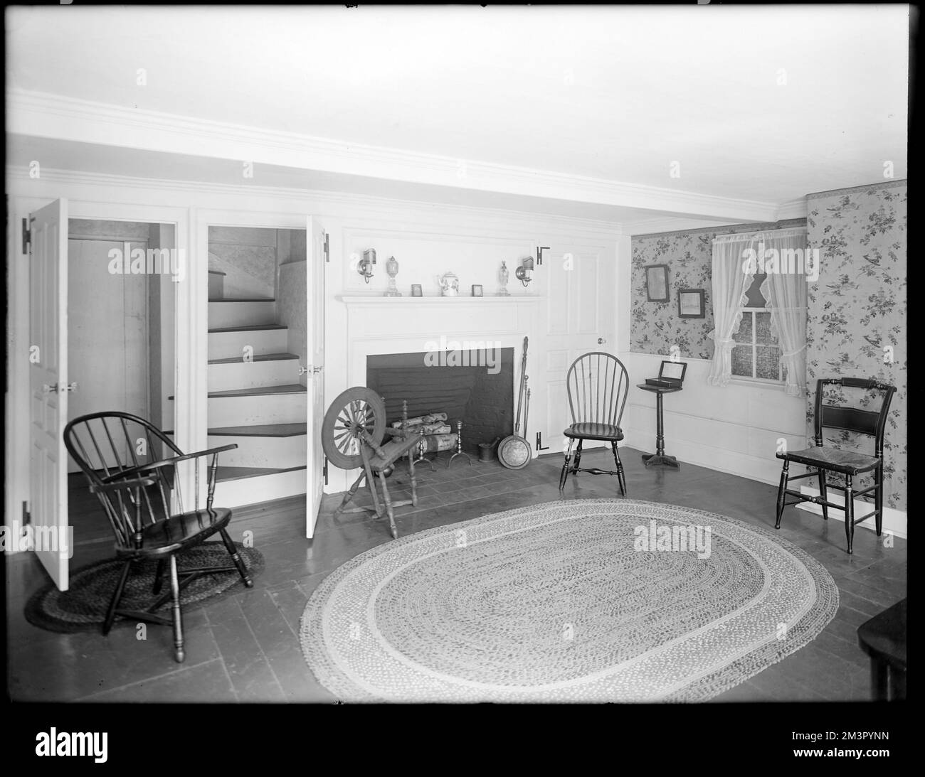 Roger G. Pierce east room with fireplace and two open doors, stairway ...