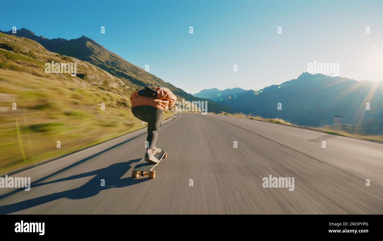 Cinematic downhill longboard session. Young woman skateboarding and ...