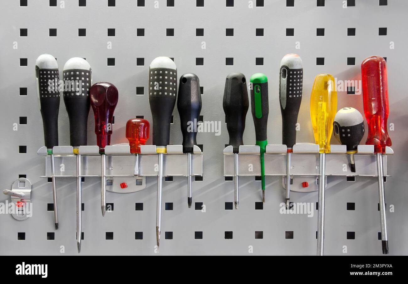 Screw drivers hanging on the tool panel Stock Photo - Alamy