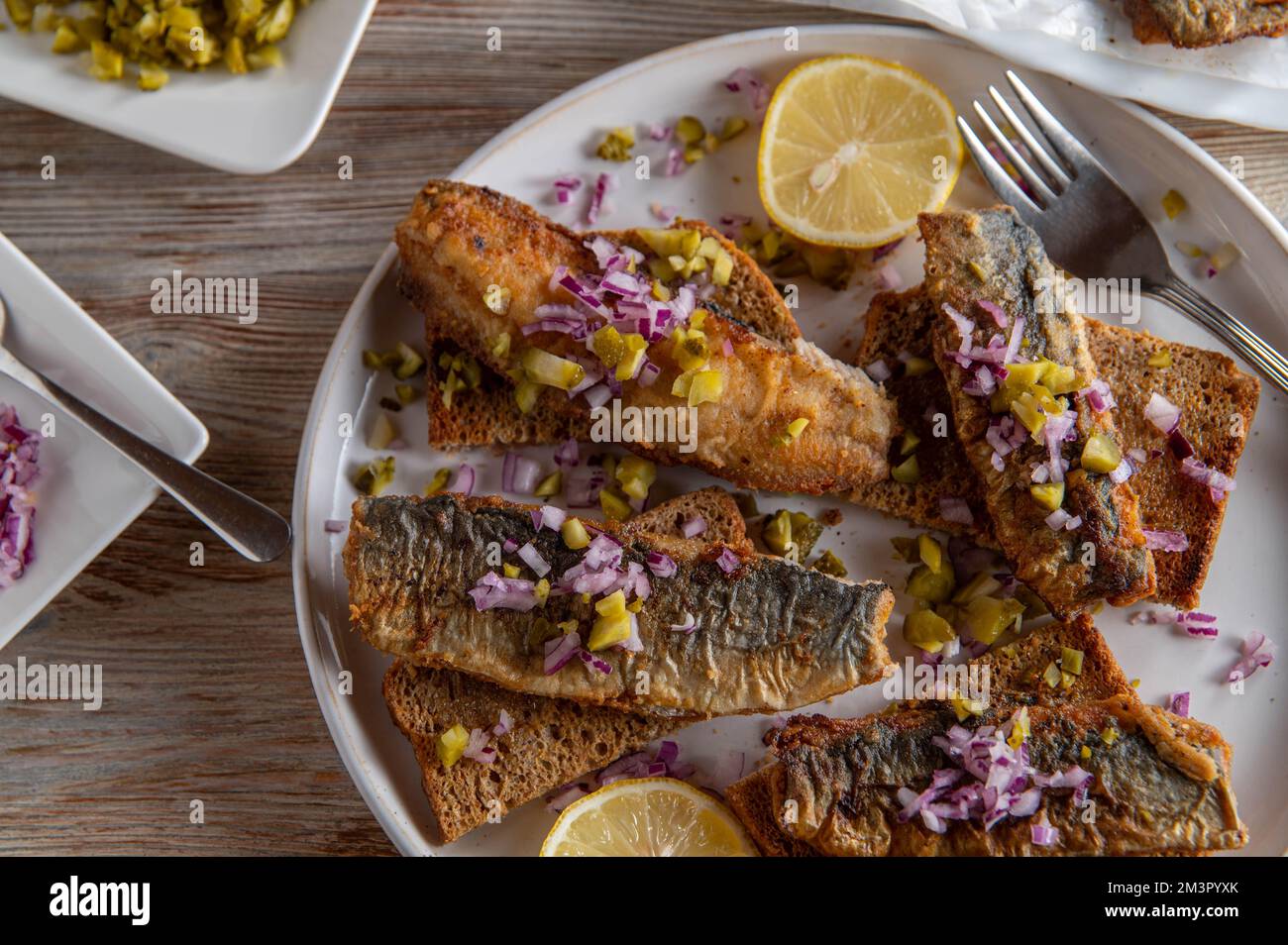 Fish sandwiches with pan fried herring, toasted rye bread, pickles and ...