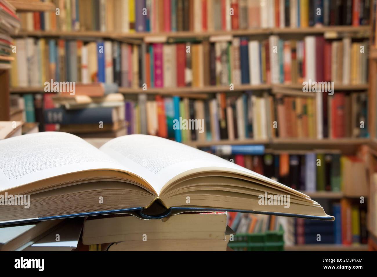 Old open book with library background Stock Photo - Alamy