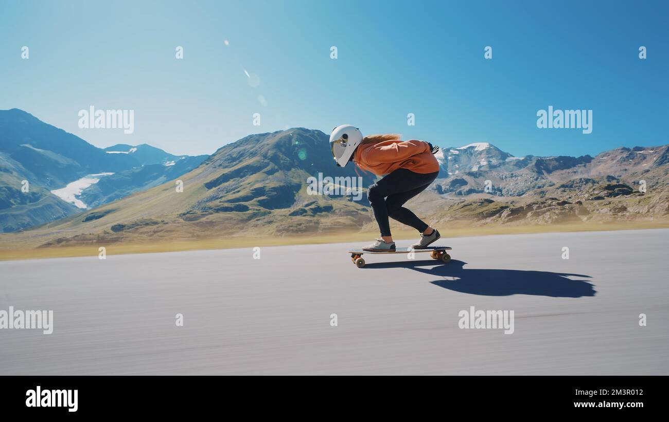 Cinematic downhill longboard session. Young woman skateboarding and ...