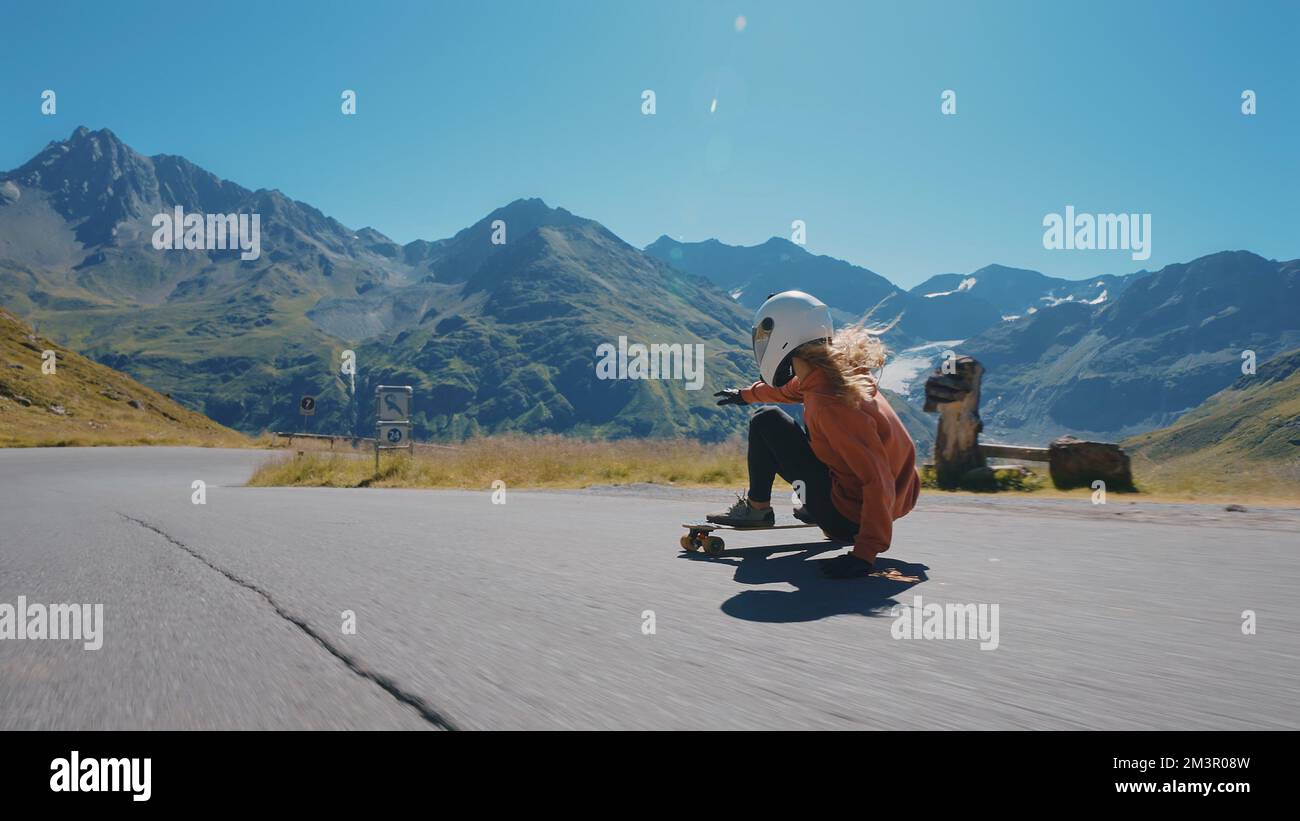 Cinematic downhill longboard session. Young woman skateboarding and ...