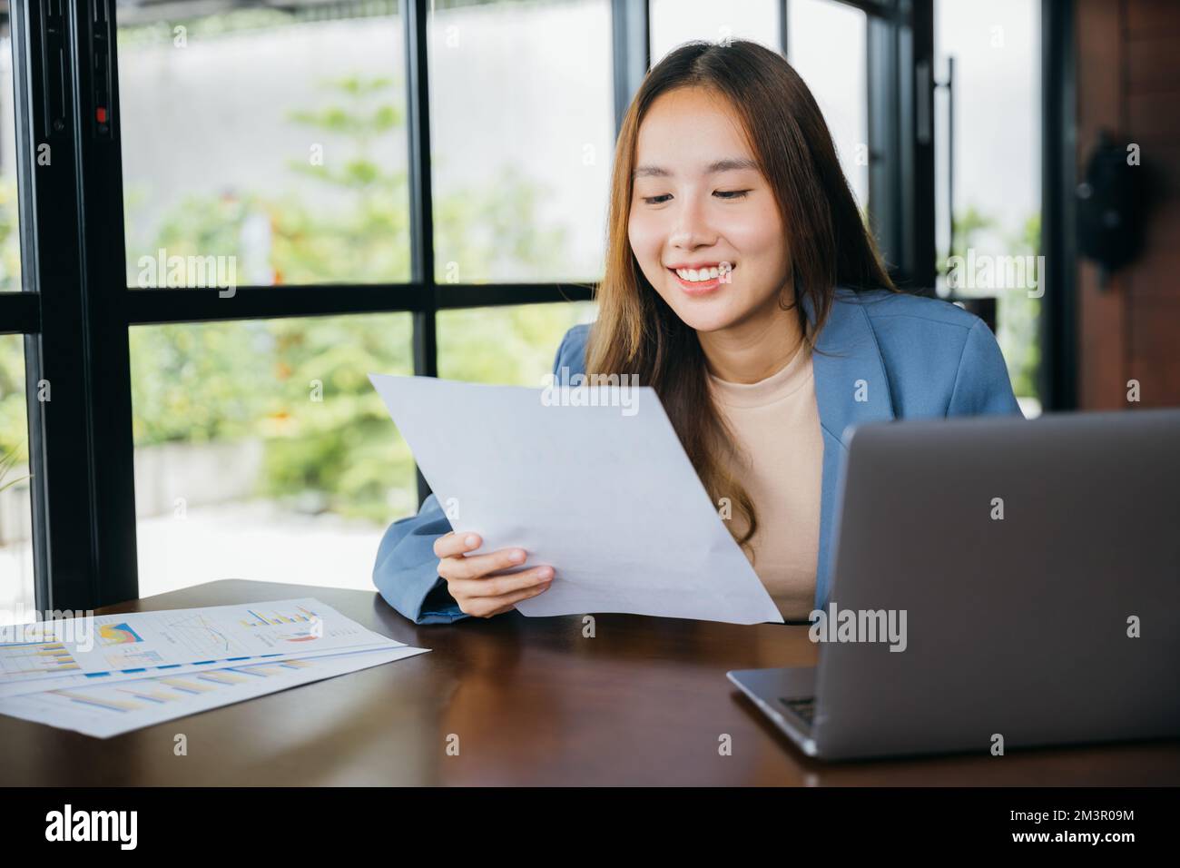 Happy accounting female reviewing data in financial charts and graphs ...