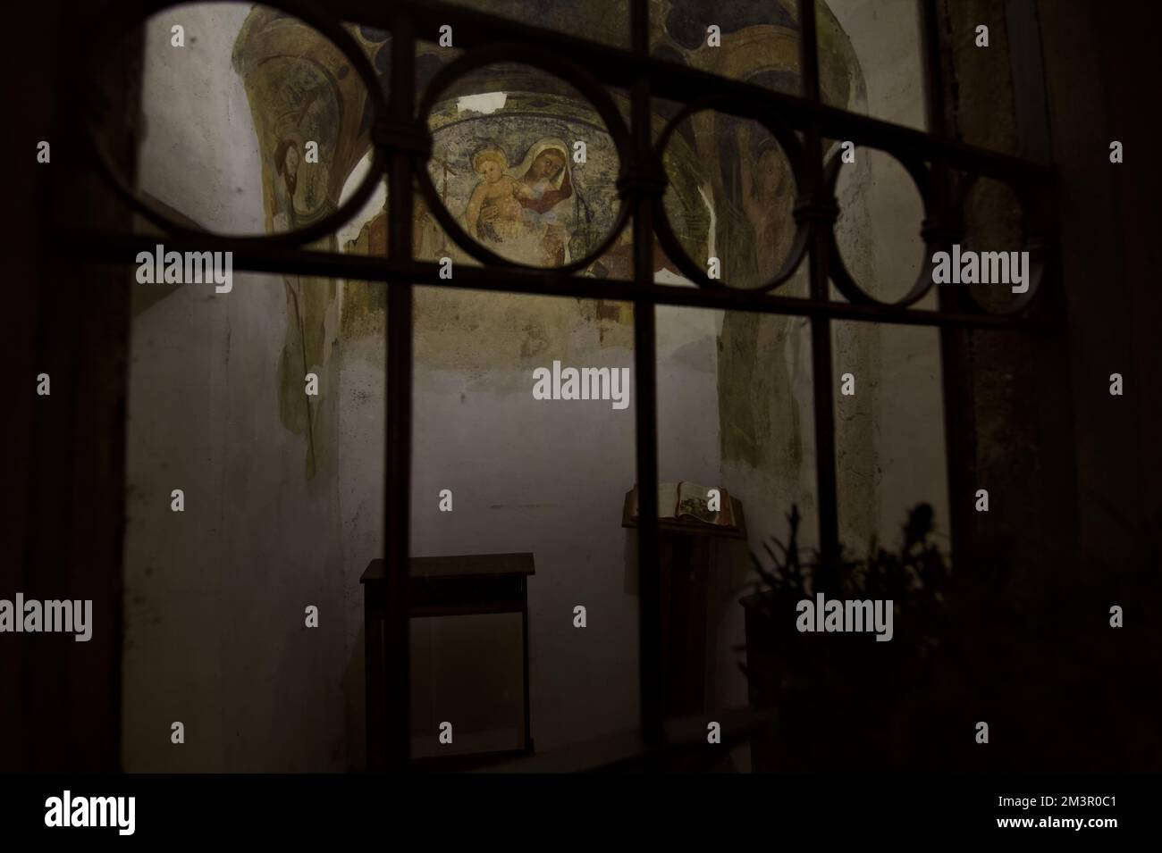 Small chapel at night seen through a grate Stock Photo - Alamy