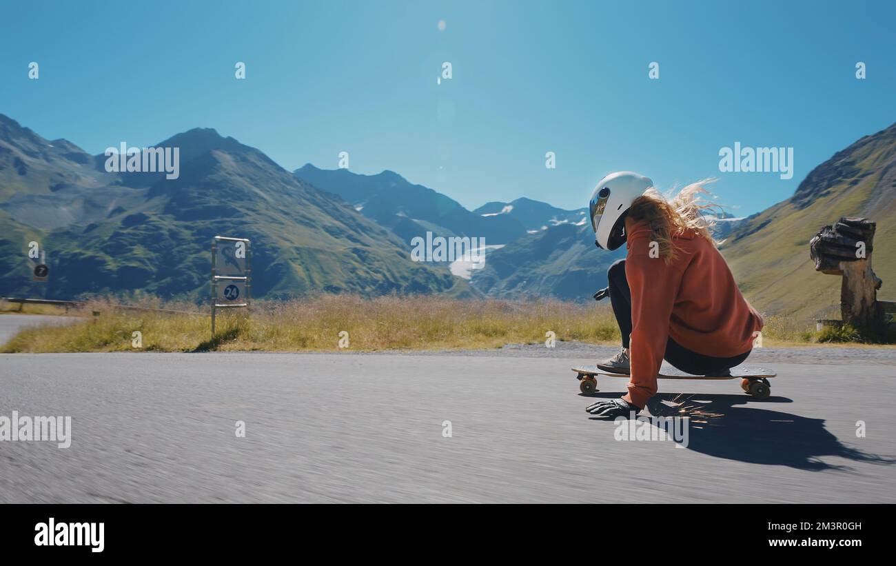 Cinematic downhill longboard session. Young woman skateboarding and ...