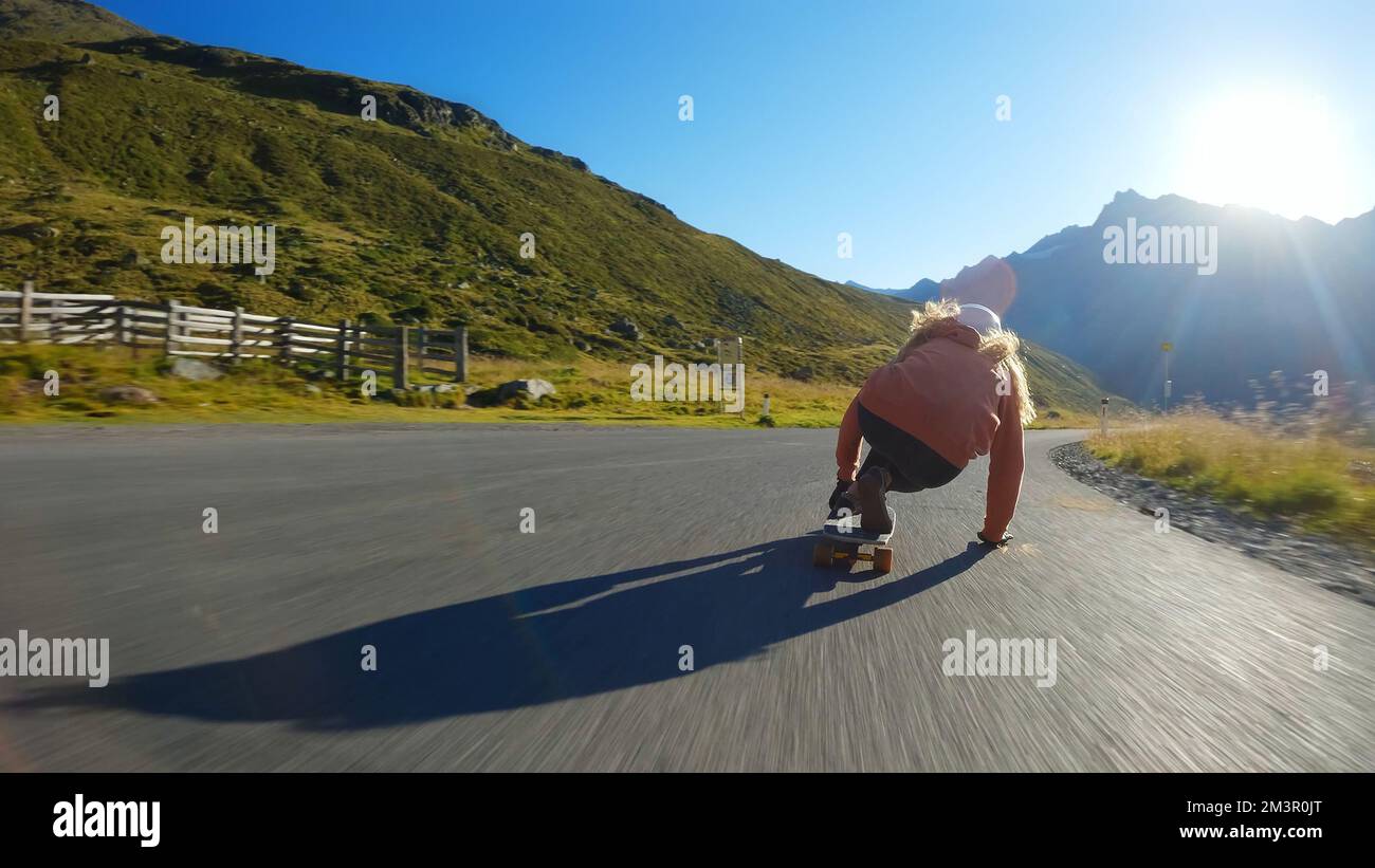 Cinematic downhill longboard session. Young woman skateboarding and ...