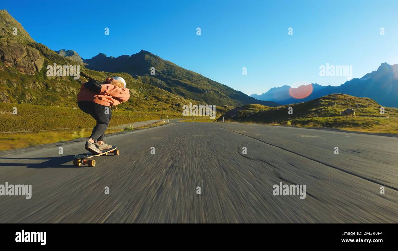 Cinematic downhill longboard session. Young woman skateboarding and ...