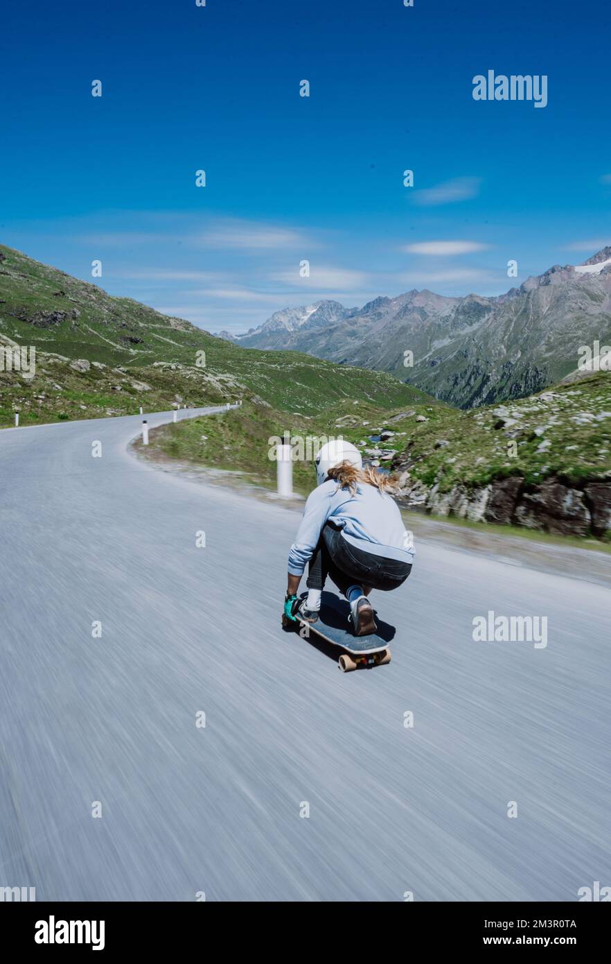 Cinematic downhill longboard session. Young woman skateboarding and ...