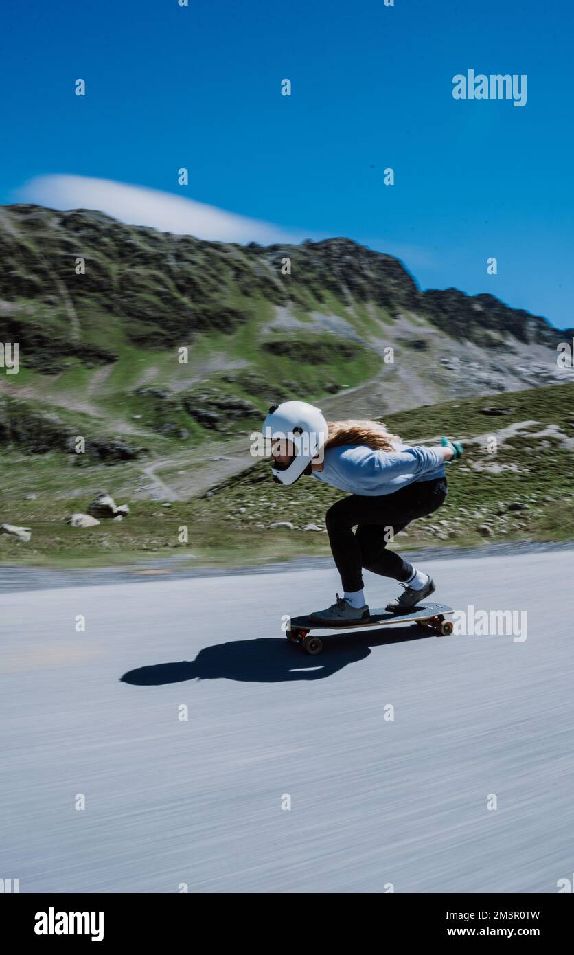 Cinematic downhill longboard session. Young woman skateboarding and ...