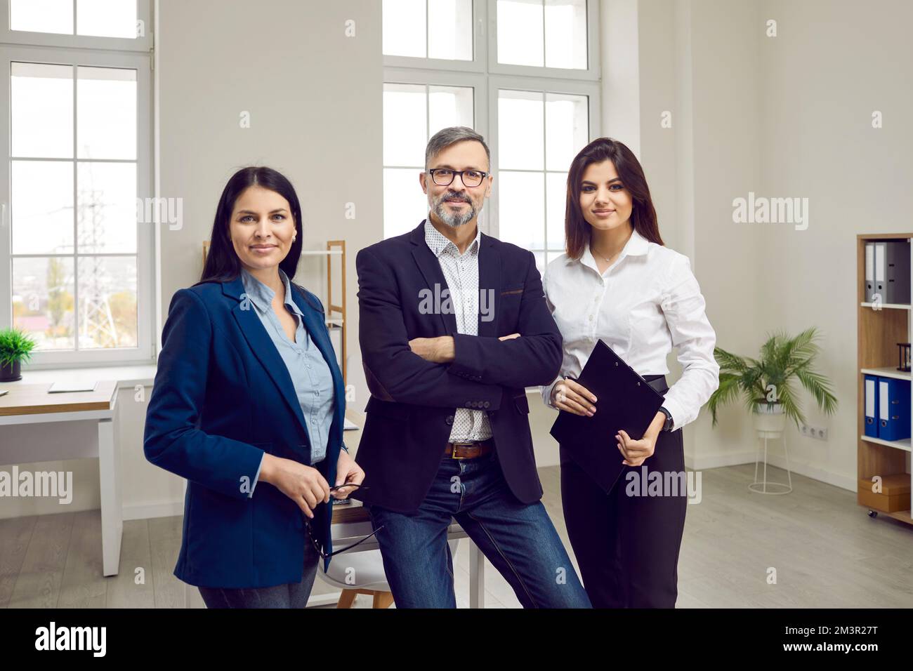Portrait of business team standing together in office Stock Photo - Alamy