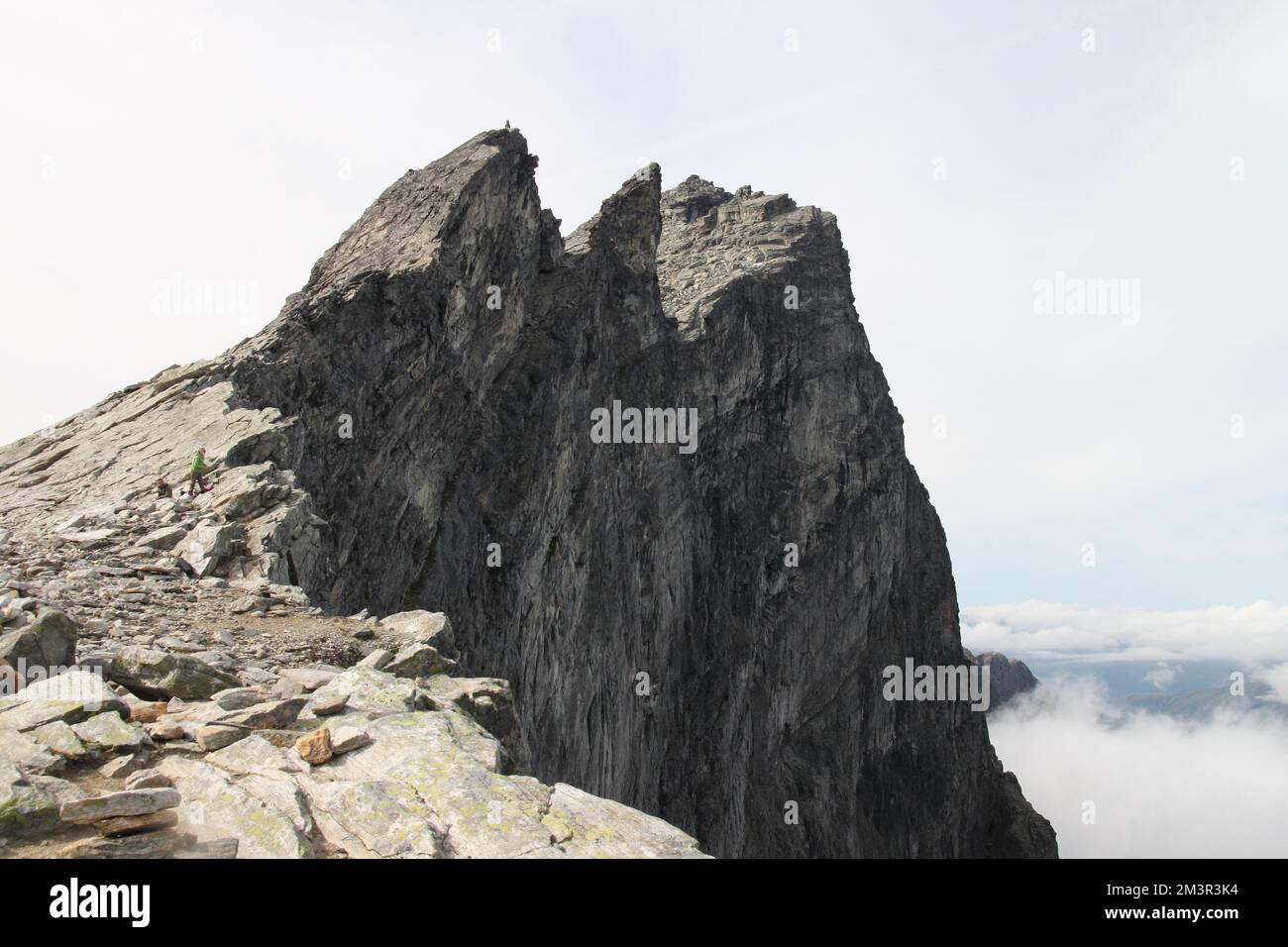The sharp peak of a big rocky mountain against the bright sky with ...