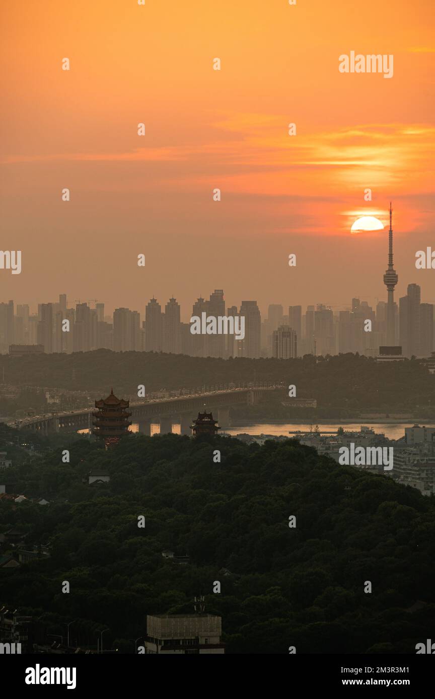 A vertical shot of Chinese Pagodas with the Wuhan city skyline and the ...