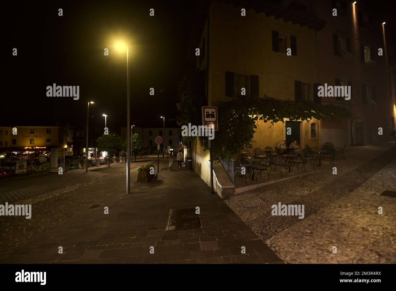 Square with restaurant and people dining at night Stock Photo - Alamy