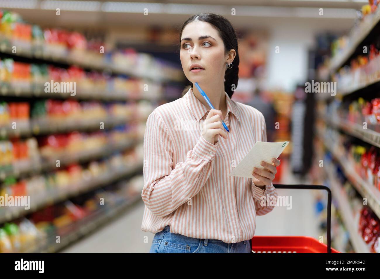 Shopping concept. Portrait of young thougtful caucasian woman choosing ...