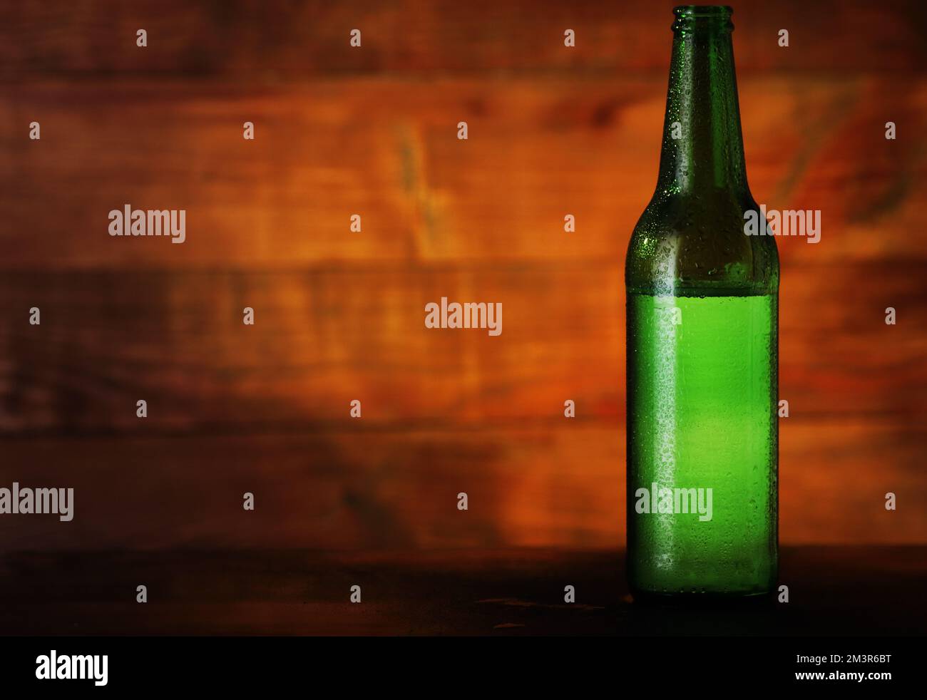 glass green bottle with liquid on a wooden background Stock Photo - Alamy