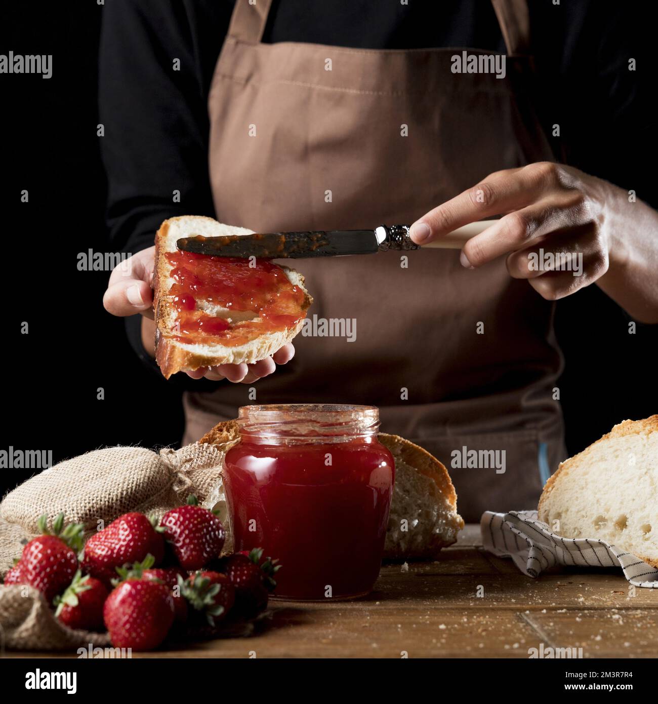 Chef spreading strawberry jam bred Stock Photo - Alamy