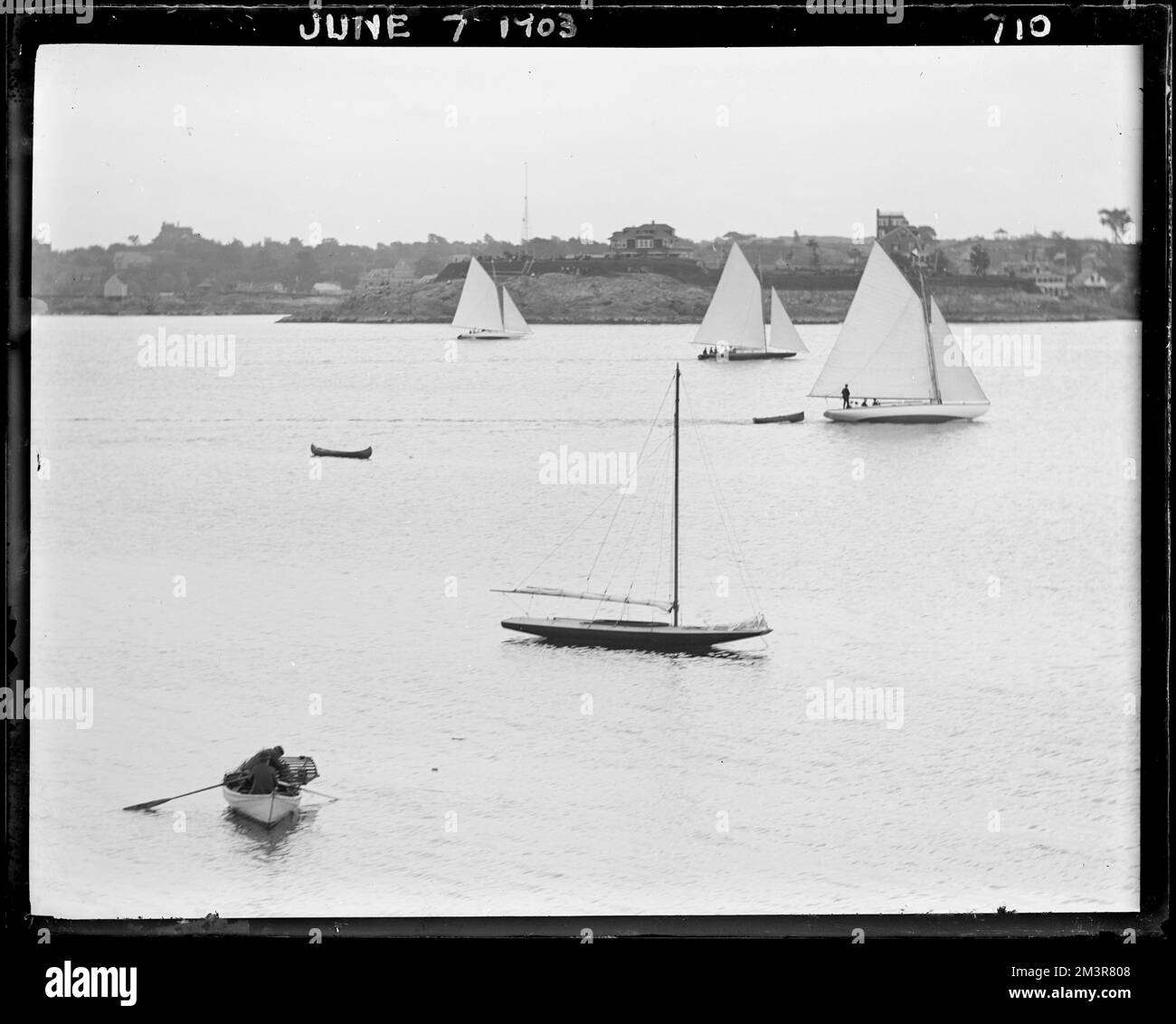 Sailboats with lobster trap and men in rowboat, Marblehead Harbor ...