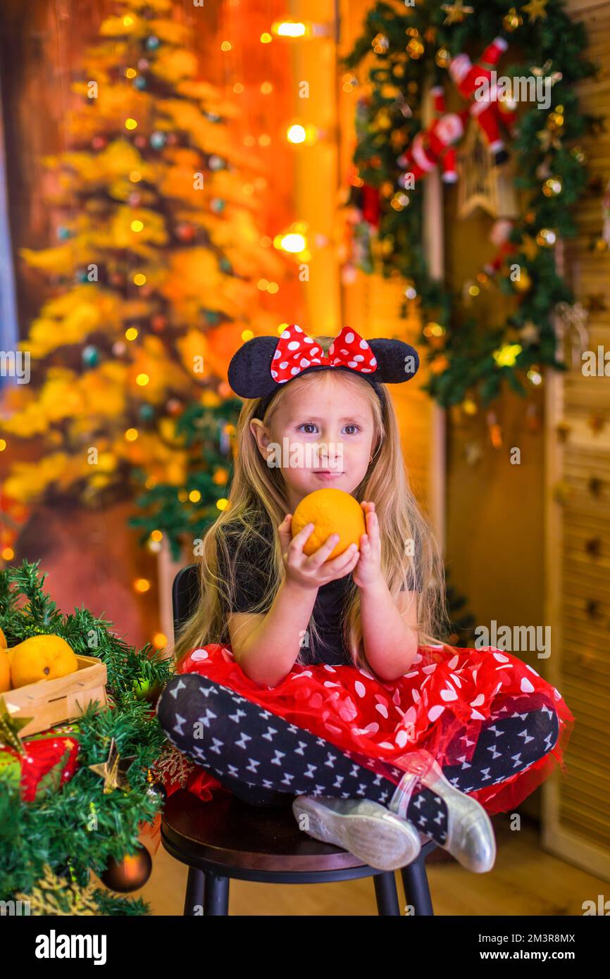 Girl in a New Year's costume at a table with tangerines Stock Photo - Alamy