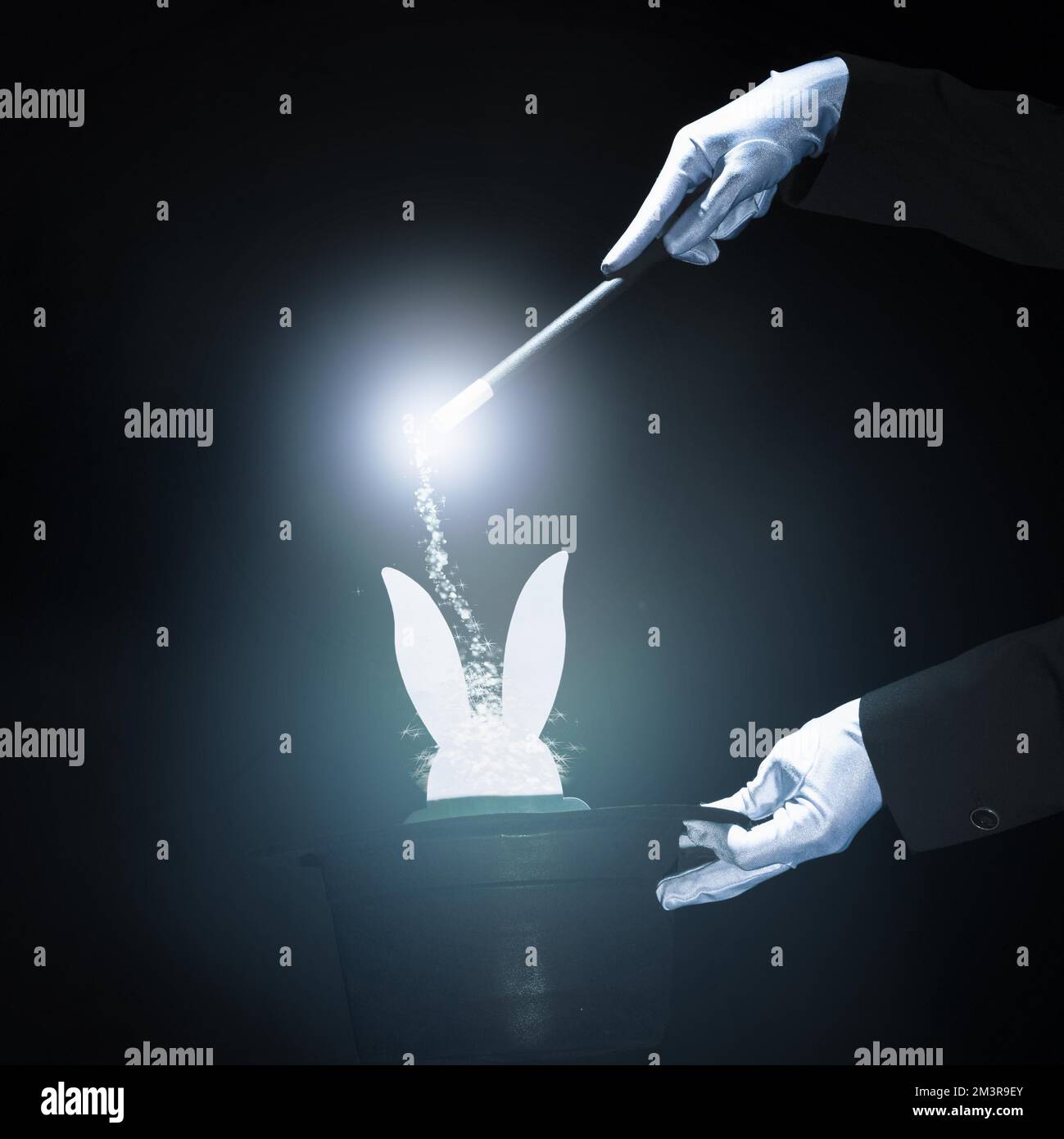 Magician performing trick with magic wand against black glowing ...