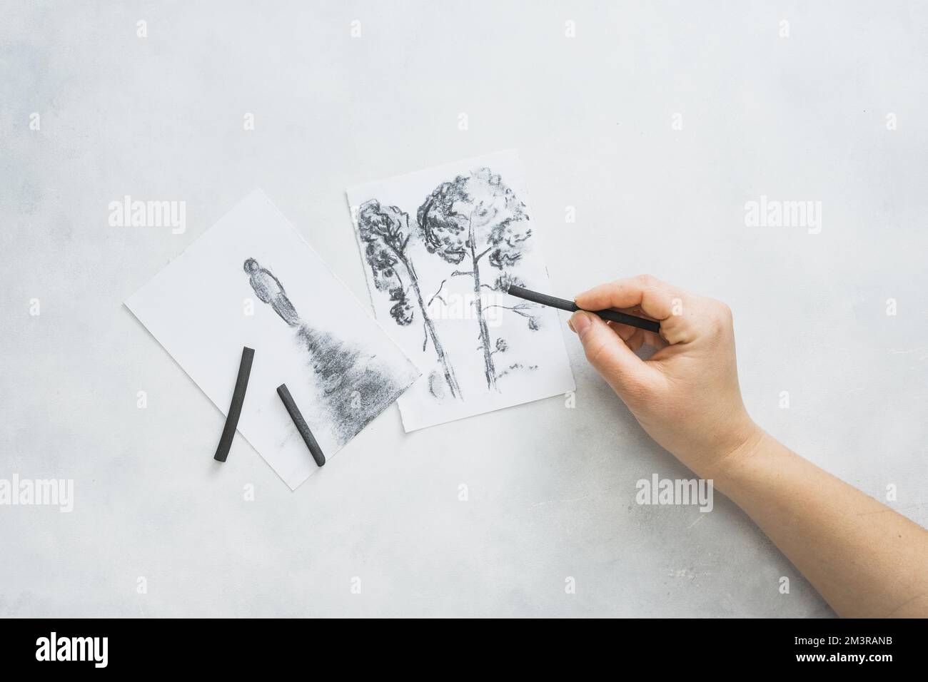 Person s hand sketching beautiful drawing with charcoal stick white ...