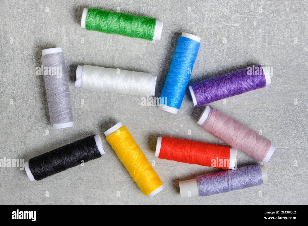 Reels with multi colored sewing threads gray concrete background Stock ...