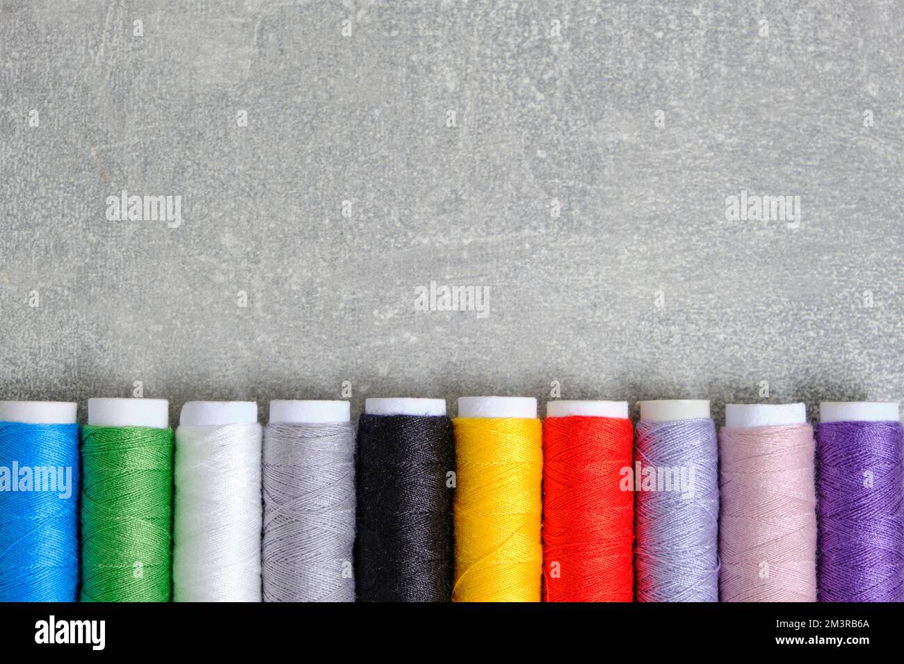 Reels with multi colored sewing threads gray concrete background Stock ...