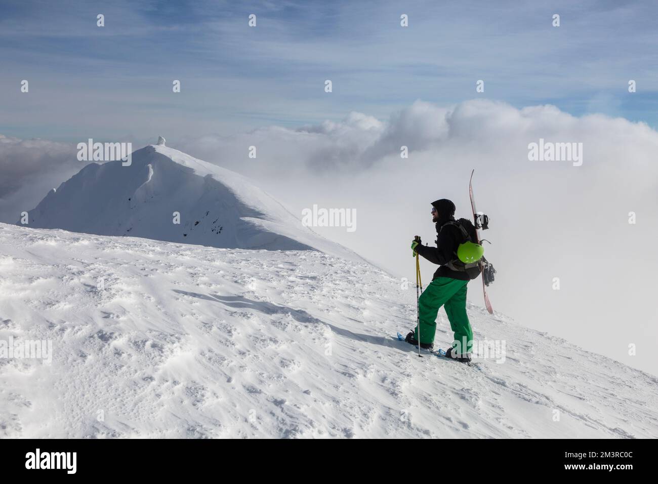 brave hiker on the edge of mountain with natural sky and clouds background. Cloudy cover over ...