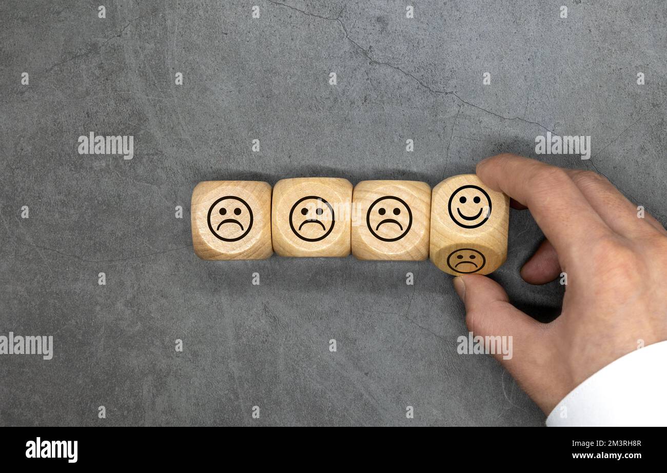 Flipping wooden cube blocks from sad to smiling Stock Photo - Alamy