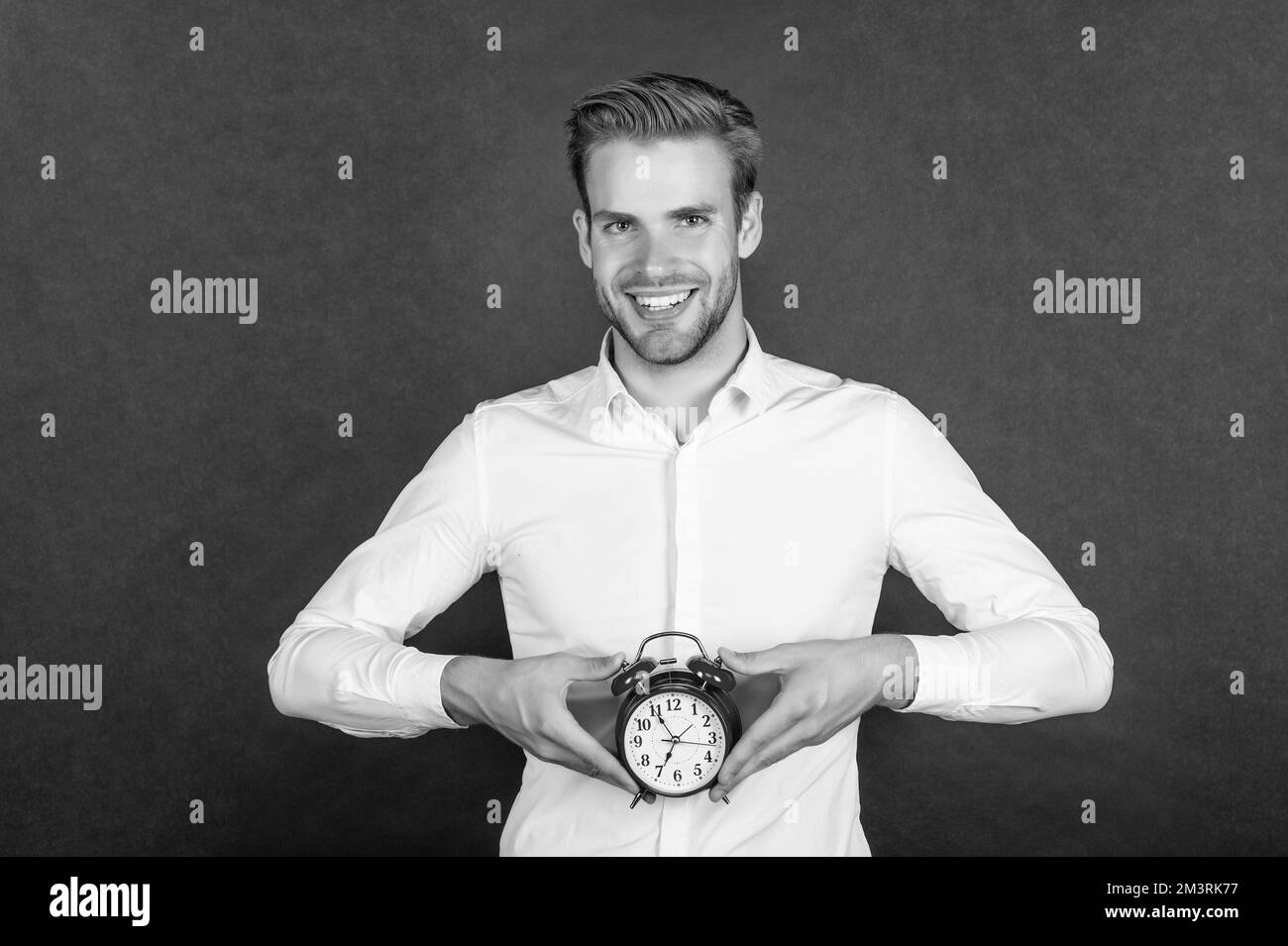 meeting deadline. guy with alarm clock on black background Stock Photo ...
